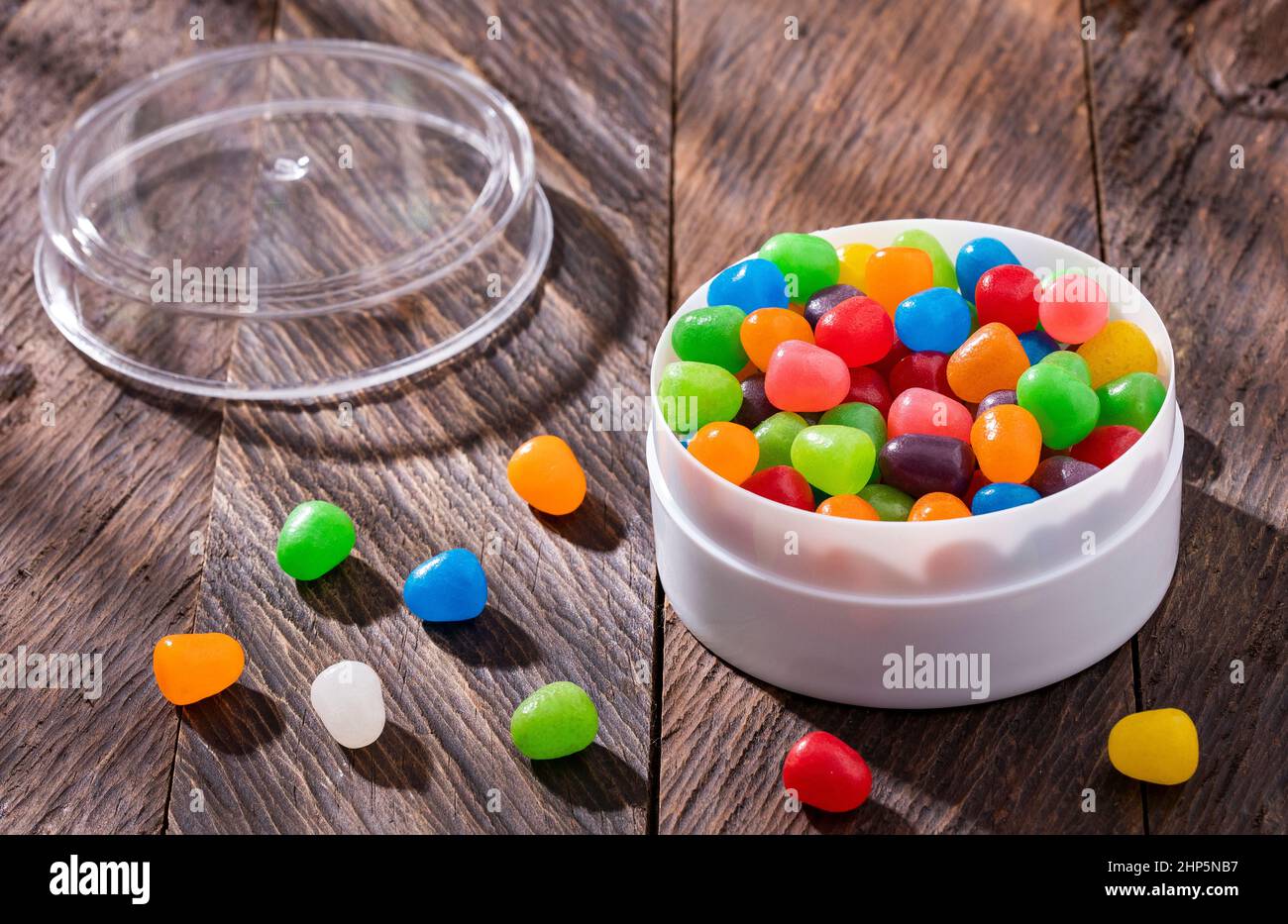 Small colored candies in the plastic container Stock Photo - Alamy