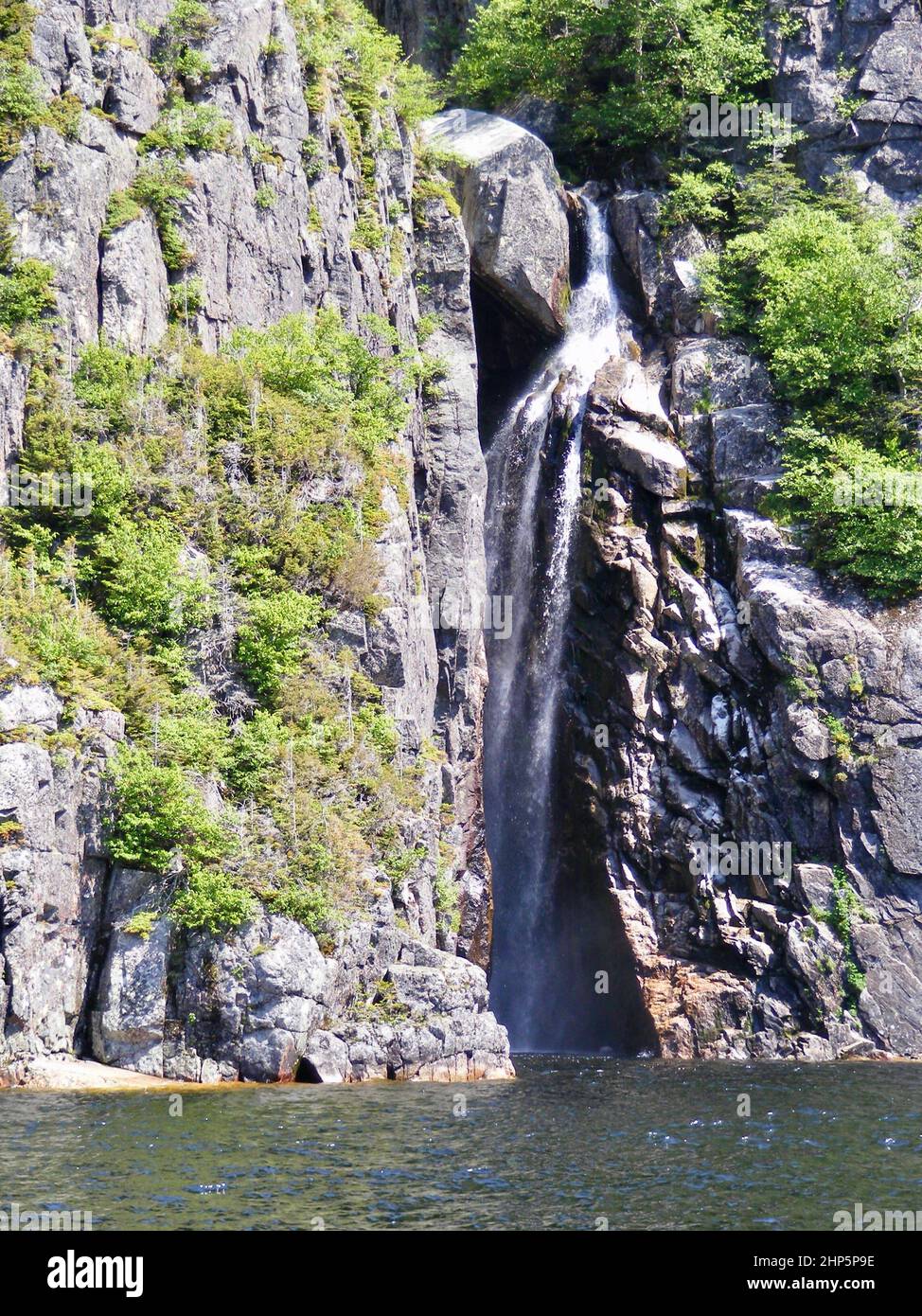 Large waterfall plunging from cliff into Western Brook Pond Stock Photo ...