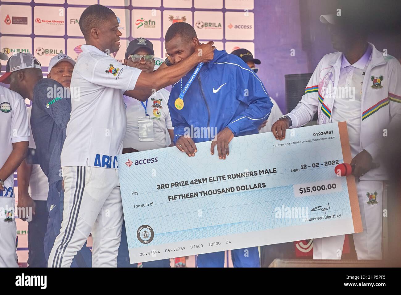 3rd place marathon winner, Emmanuel Naibei receives a medal and prize ...