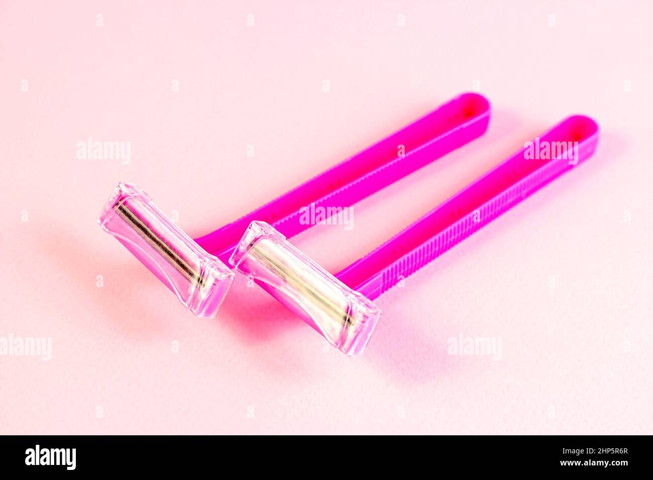 Pink disposable woman razor on light pastel background with copy space ...