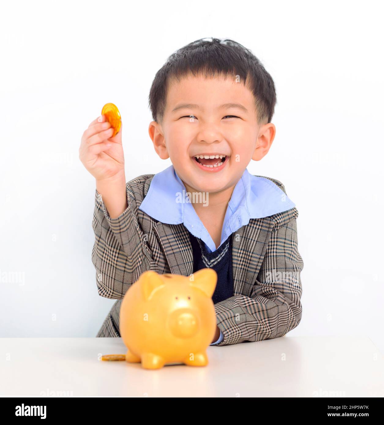 Happy little boy with coin and piggy bank Stock Photo - Alamy