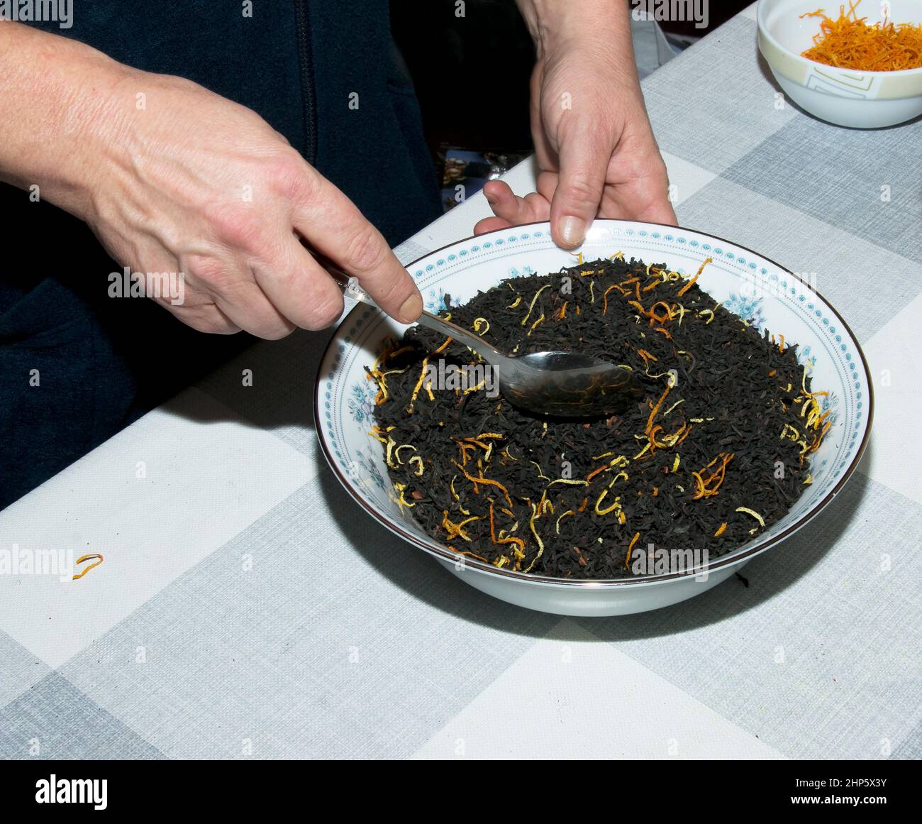 Female hands stir the tea mixture with a spoon. The process of making ...