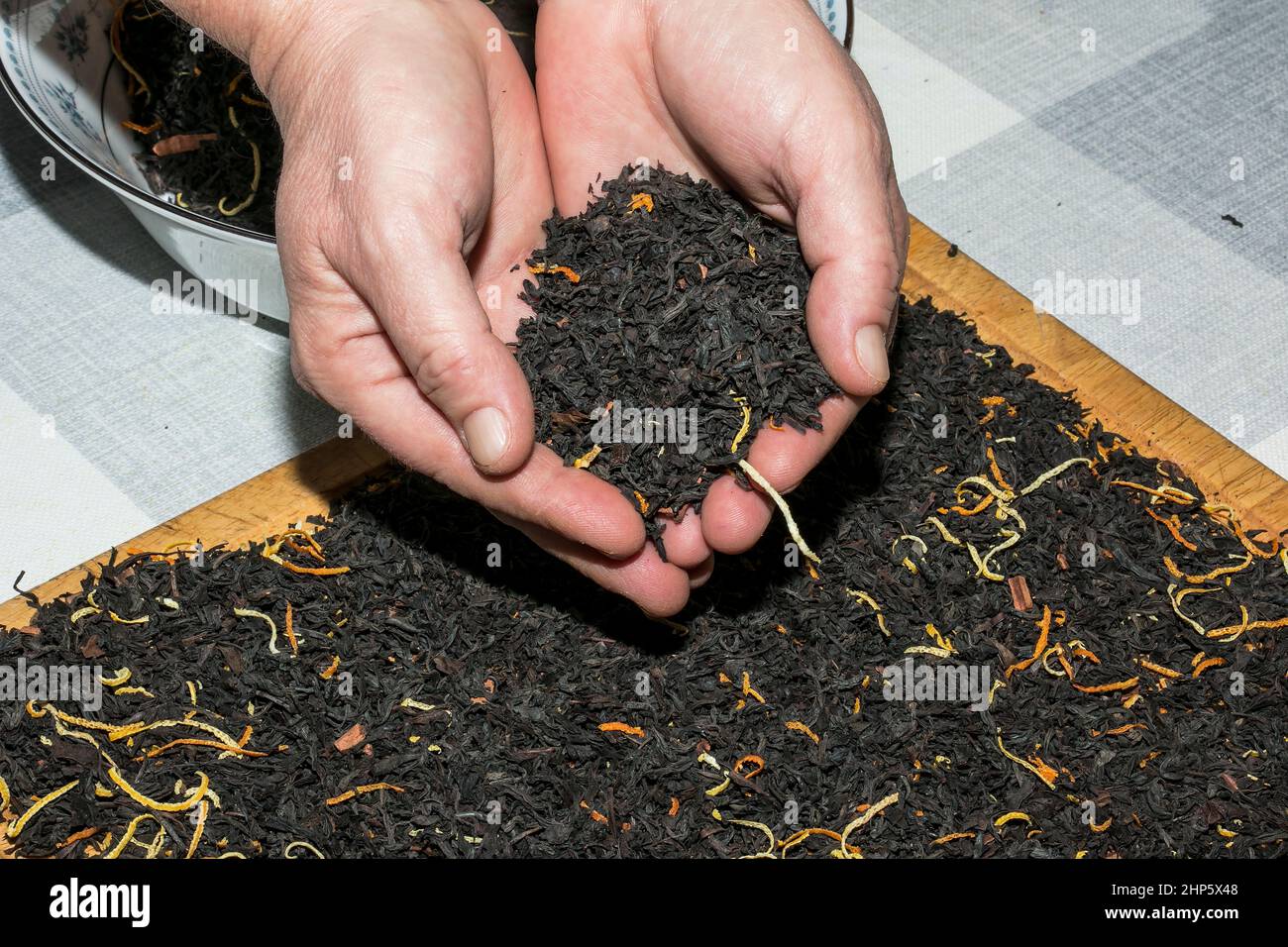 The brewing tea is ready. Female hands check the drying of the tea ...