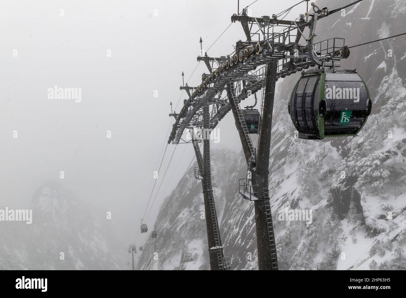 HUANGSHAN, CHINA - FEBRUARY 18, 2022 - Tourists ride cable cars at the Huangshan Mountain after ...