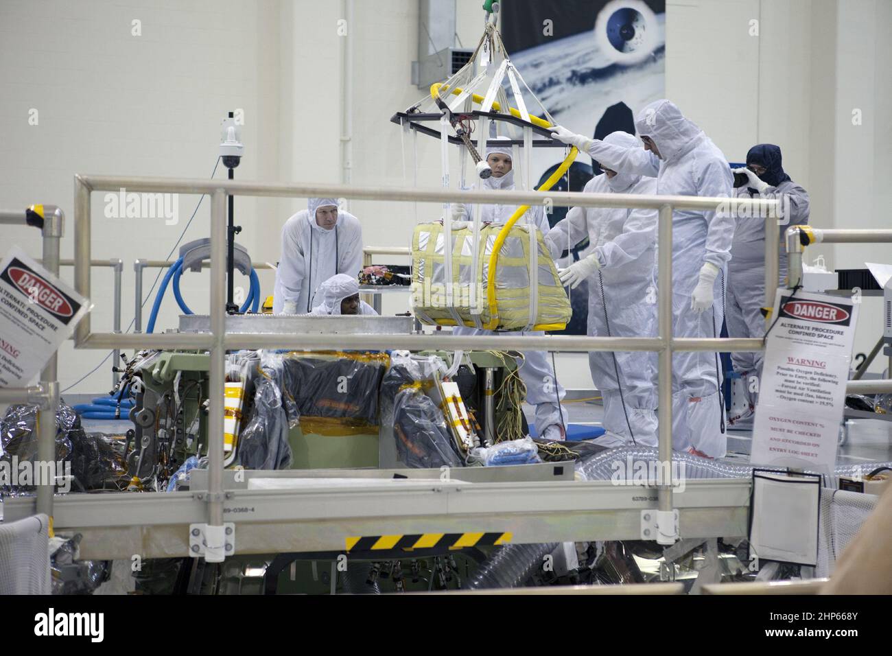 A crane lowers the main parachute for installation on the Orion ...