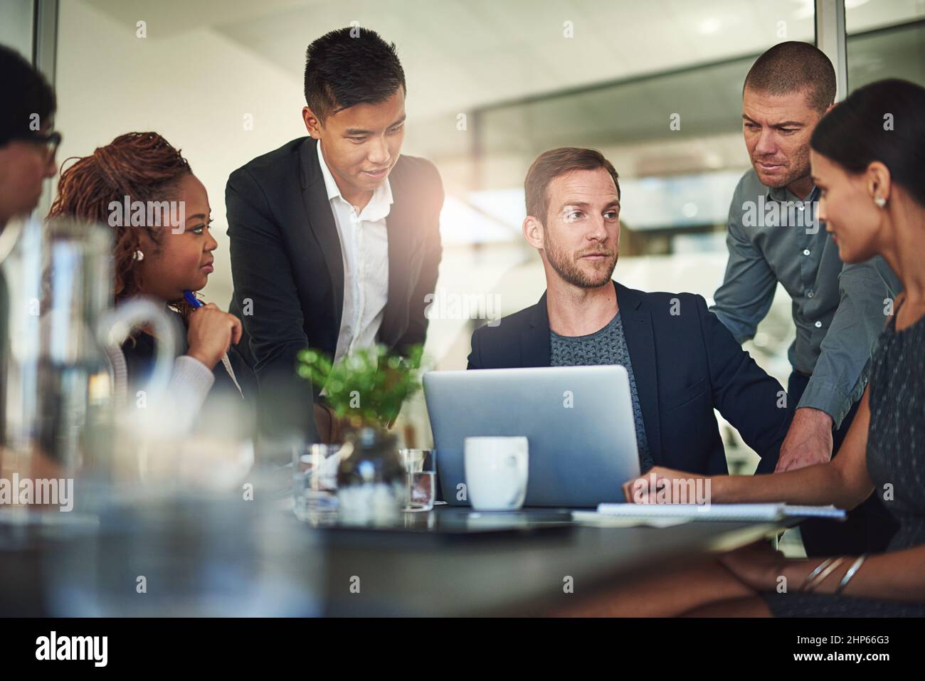 A group of people standing around a table hi-res stock photography and ...