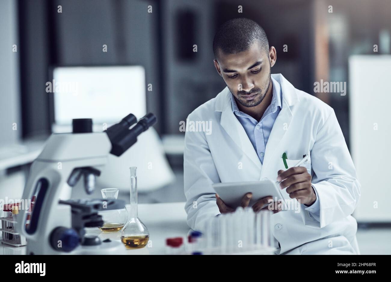 Asking questions and seeking answers. Shot of a scientist recording his ...