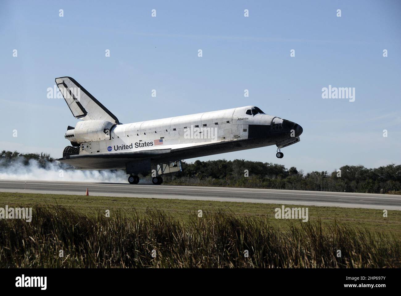 Space shuttle Atlantis kicks up dust as it touches down on Runway 33 at ...