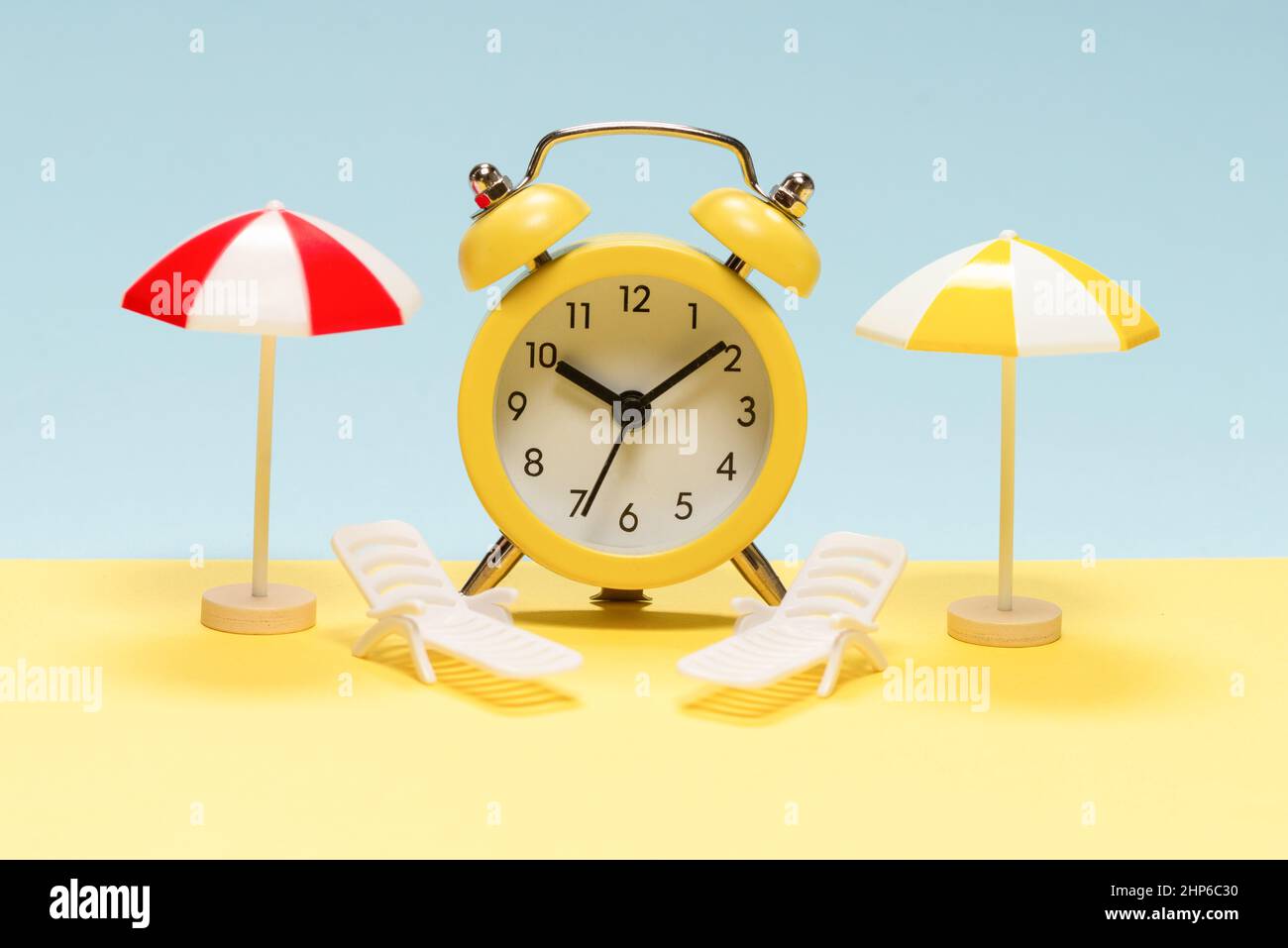 Time to travel. Sun lounger, yellow umbrella and alarm clock on a ...