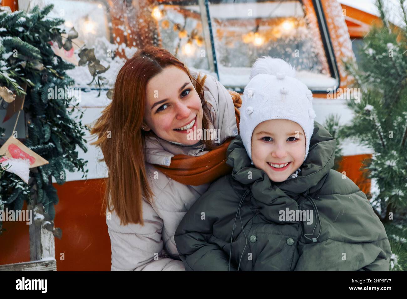 Lovely photo of young happy mother with little daughter in warm clothes ...