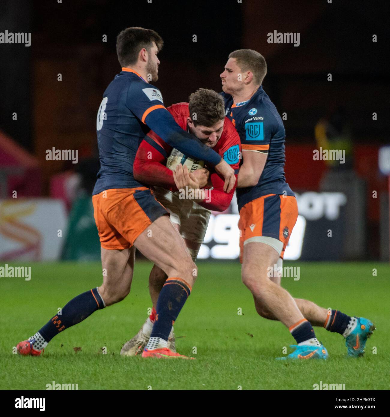 Dan Goggin of Munster tackled by Blair Kinghorn of Edinburgh and James ...