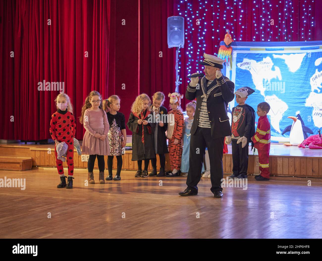 Man dressed as a captain singing on a microphone while standing on ...