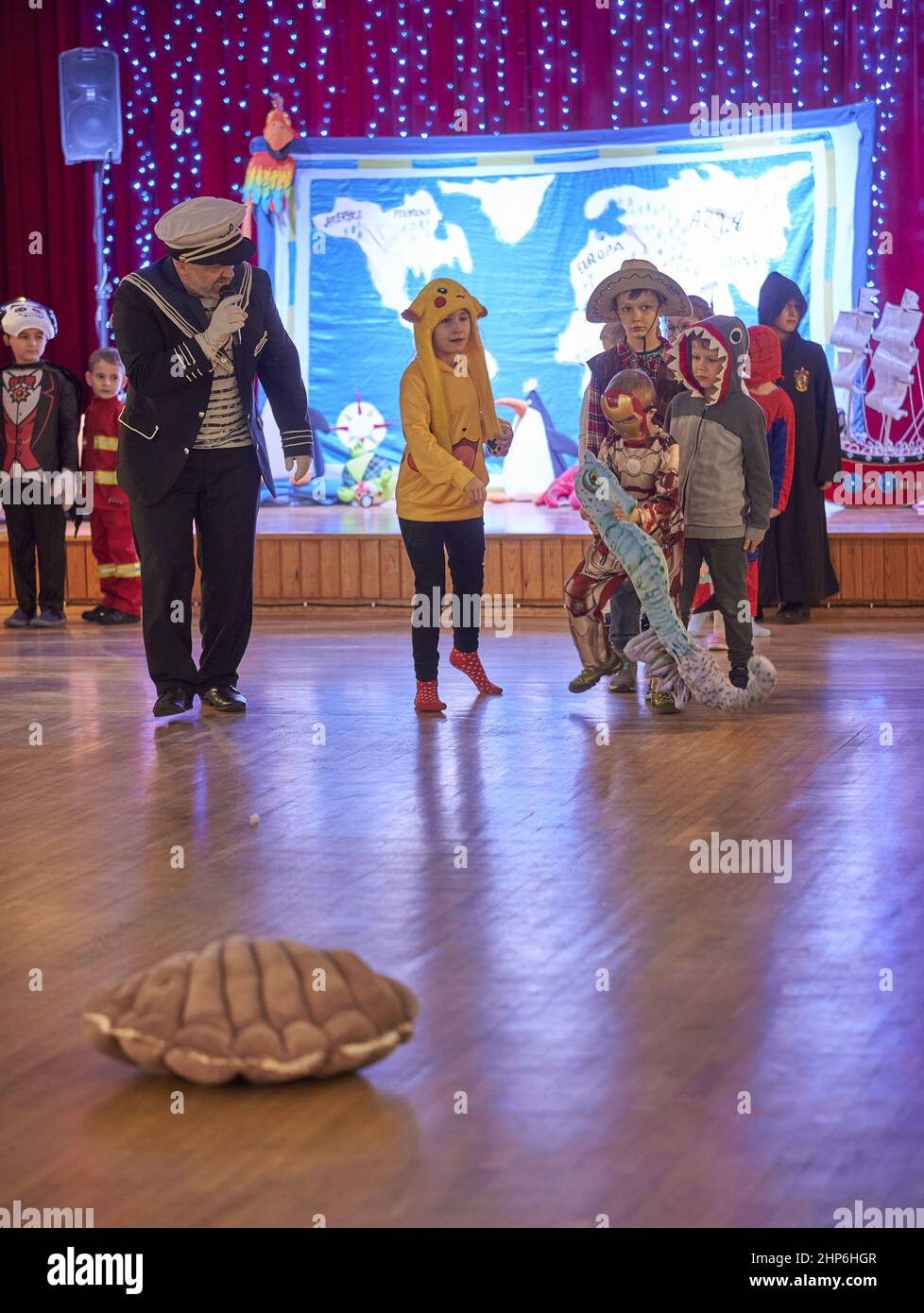 Man dressed as a captain singing on a microphone while standing on ...