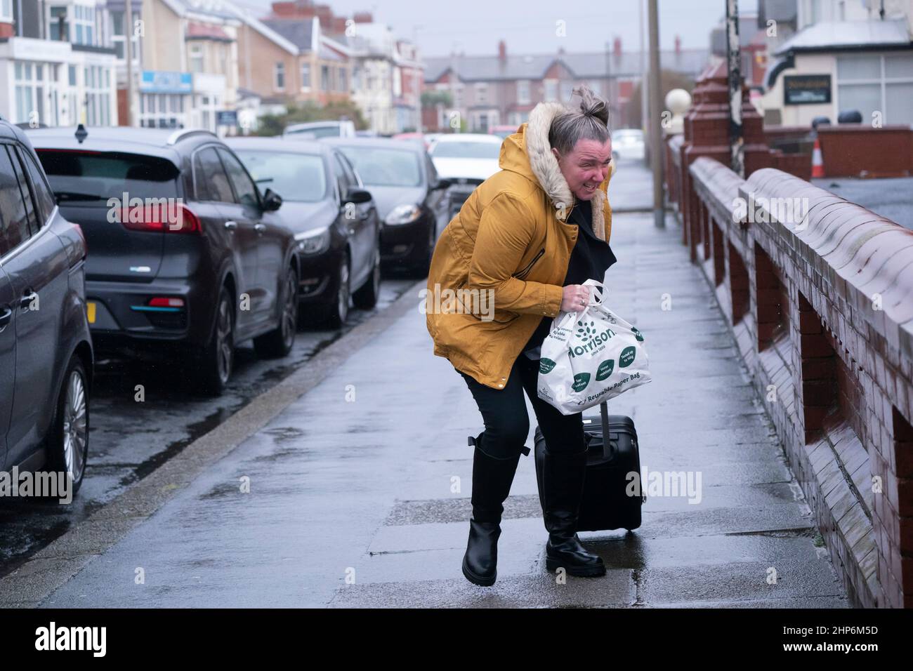 (220219) -- BLACKPOOL, Feb. 19, 2022 (Xinhua) -- A woman struggles to ...