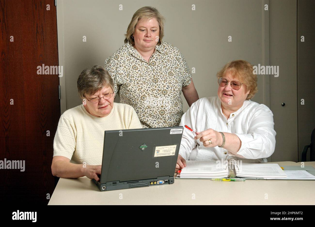 National Cancer Institute (NCI) staff (three Caucasian females) review ...