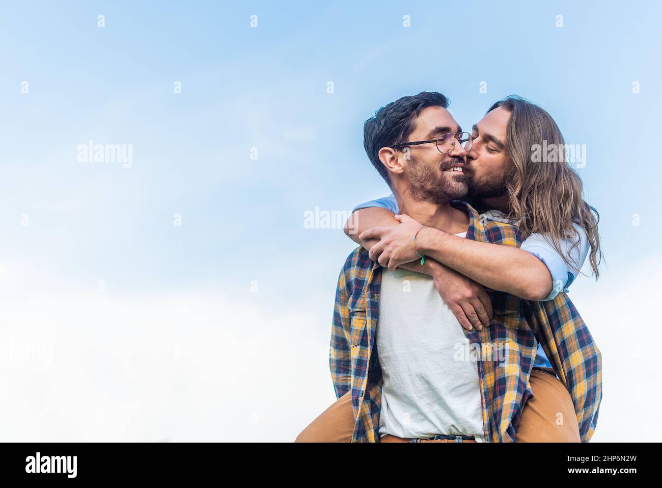 man carrying his partner on back while kissing on cheek Stock Photo - Alamy