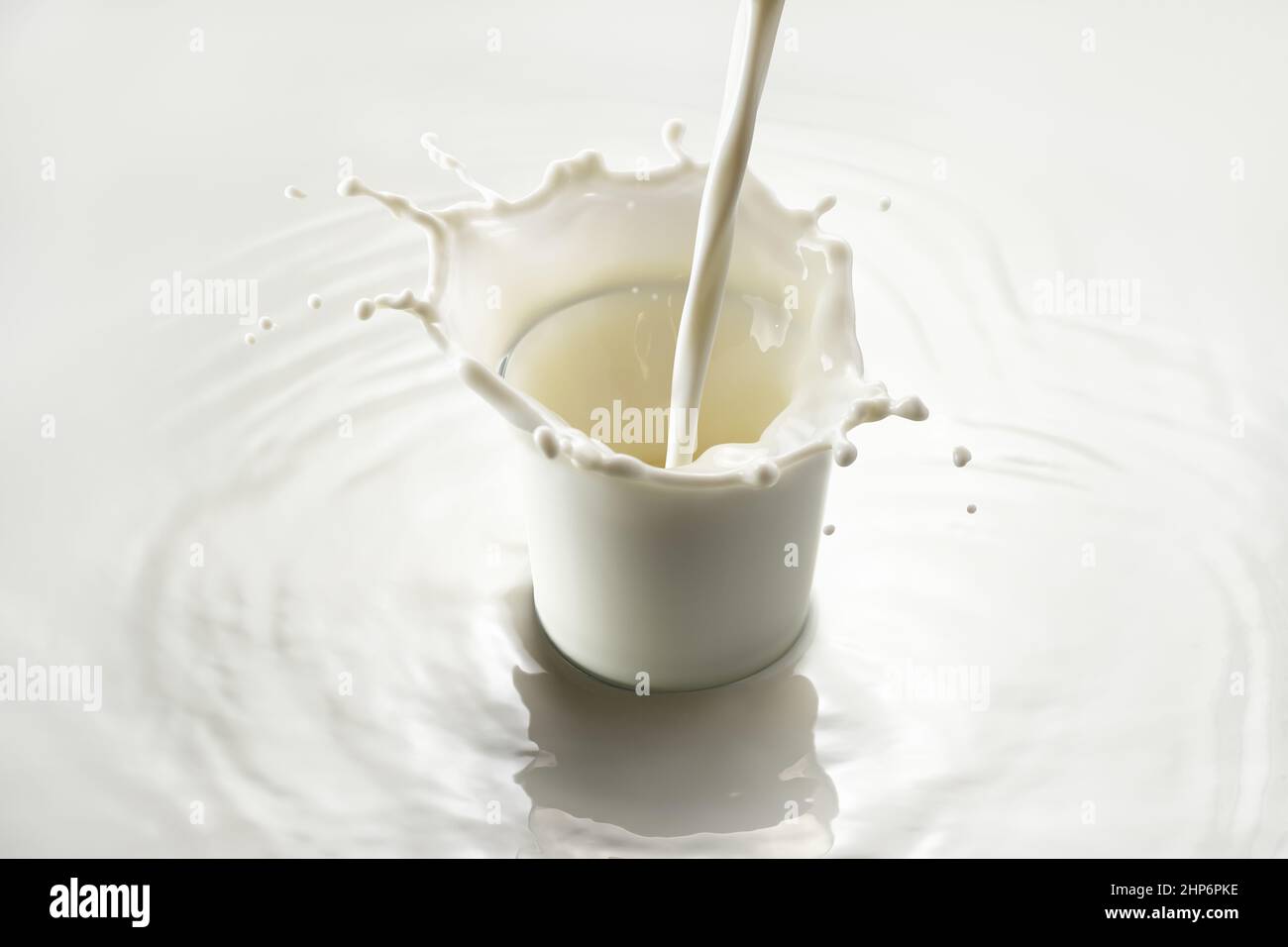 milk pouring into glass with splashes on white background Stock Photo ...