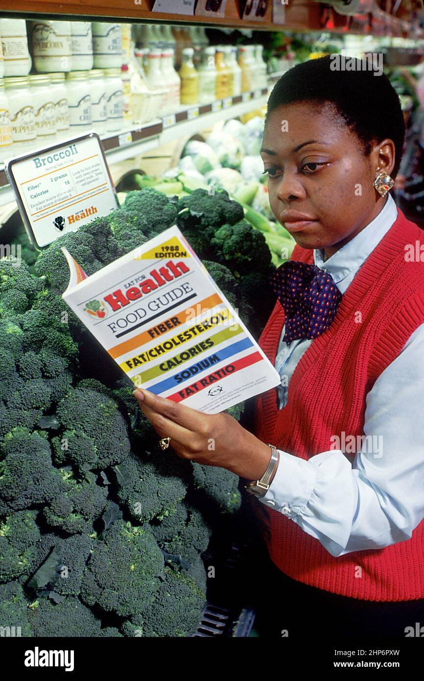 An African American woman examining the broccoli on display in the ...