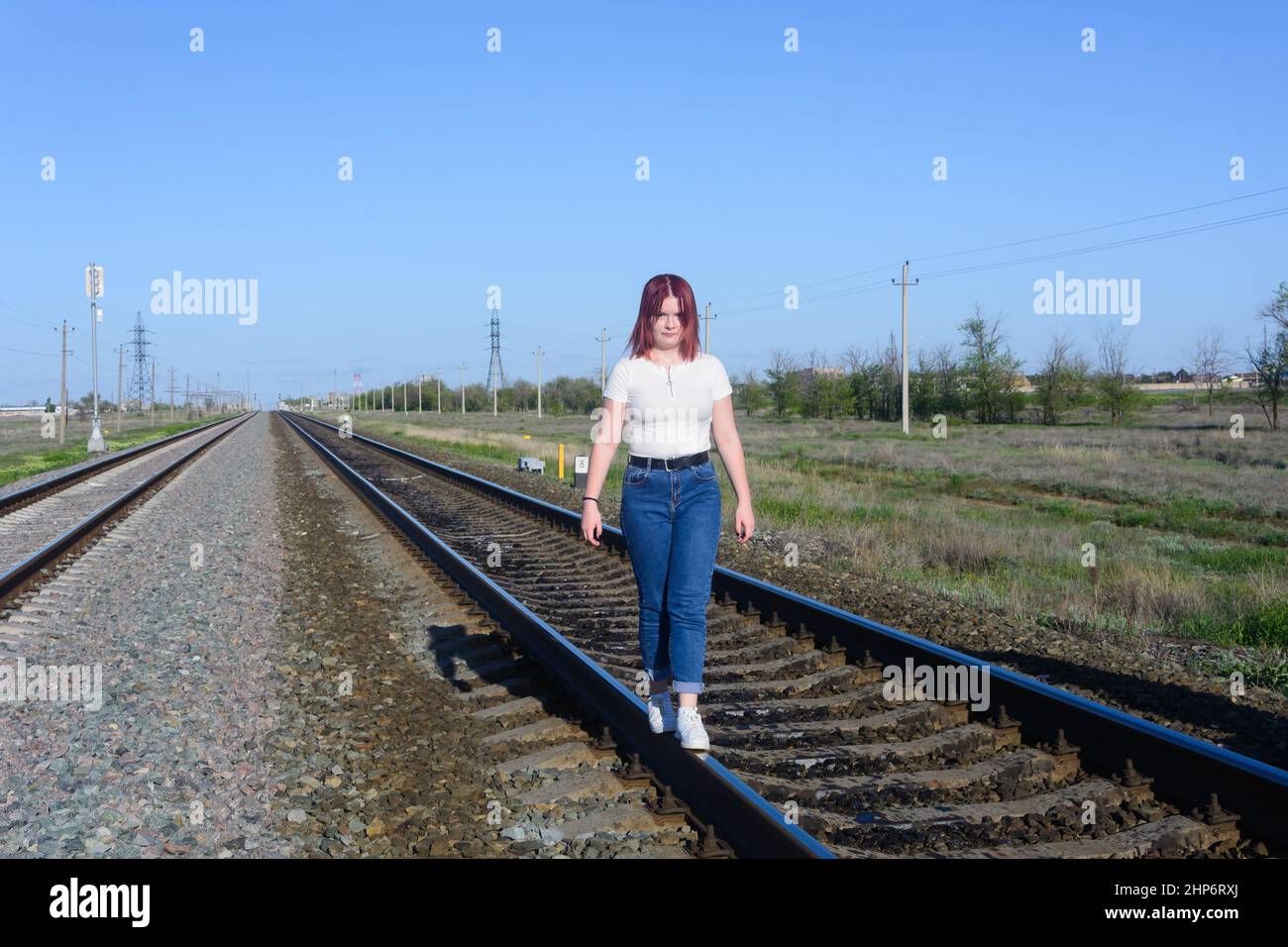 Teenage girl walks on the railroad tracks Stock Photo - Alamy