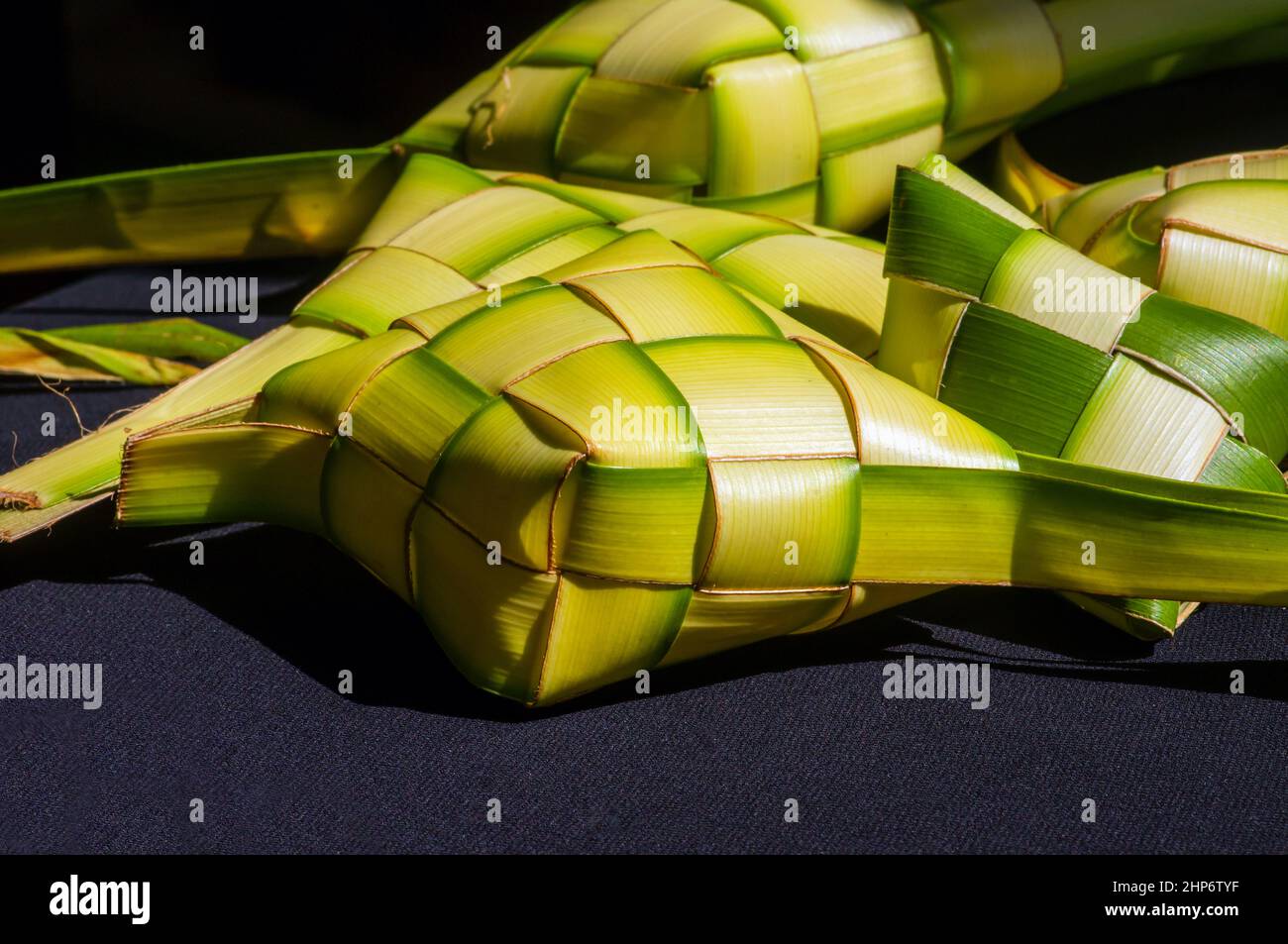 Ketupat, on dark background, a rice cake packed inside a diamond shaped ...