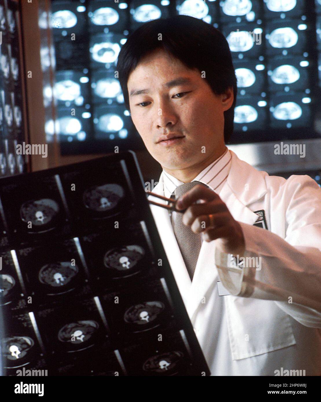 A male Asian radiologist looking at computed tomography (CT) scans ca ...