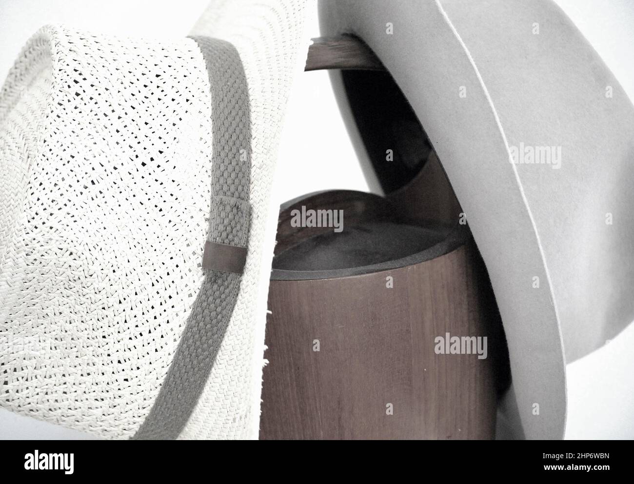 Closeup of two hats hanging on both sides of a wooden hanger isolated ...