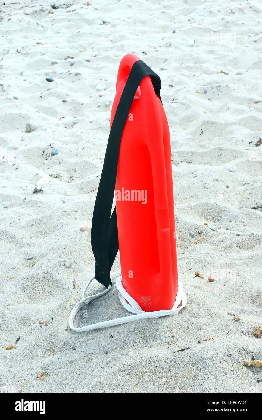 A vertical closeup of a red lifeguard float on a sandy beach Stock ...