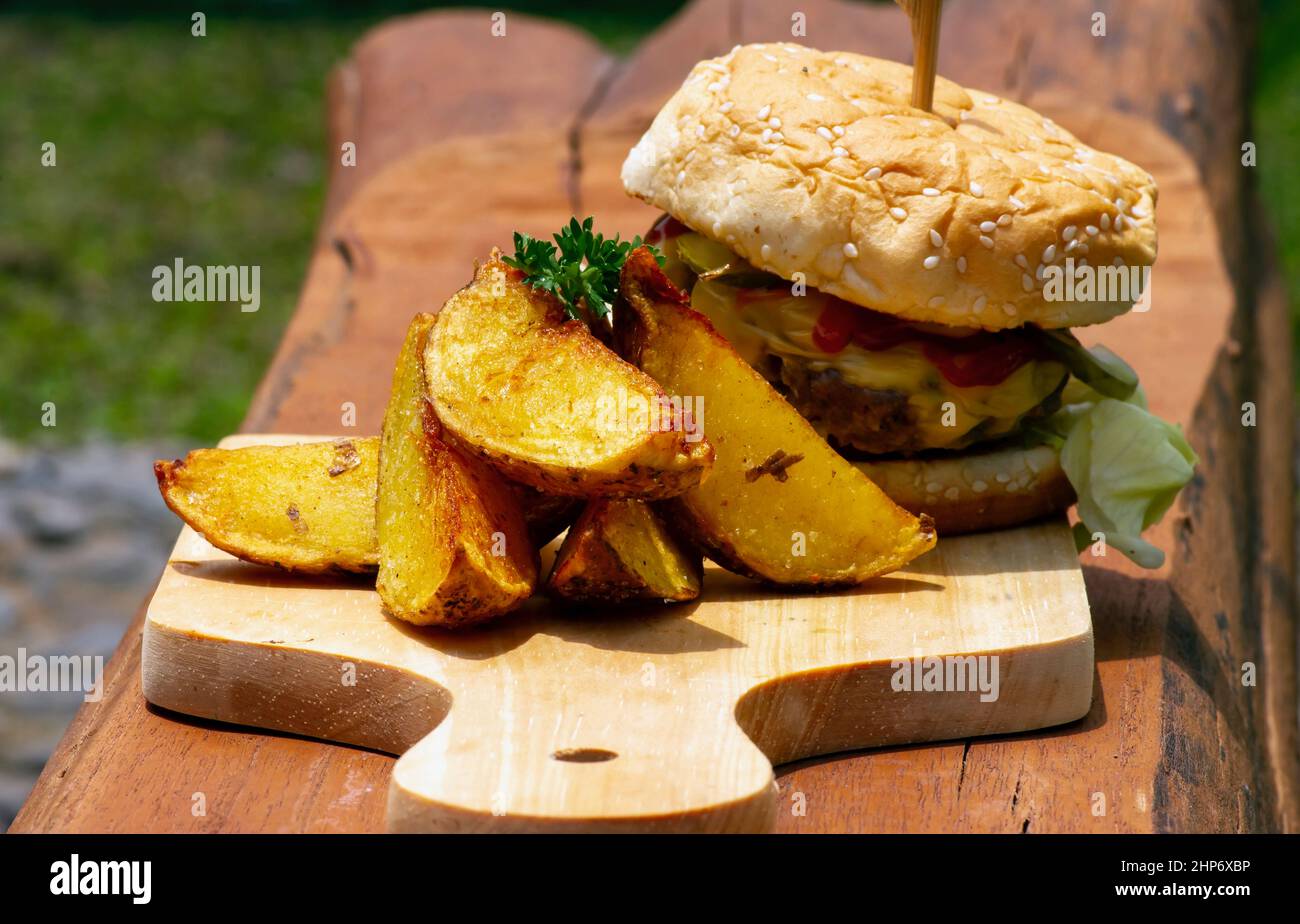 Tasty beef burger with lettuce and onion served with potatoes fries on ...