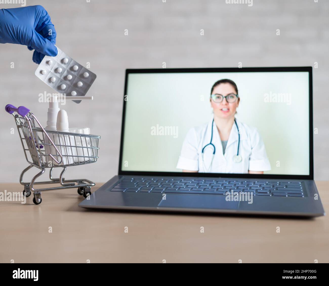 A friendly doctor conducts an online consultation on a laptop. A gloved ...