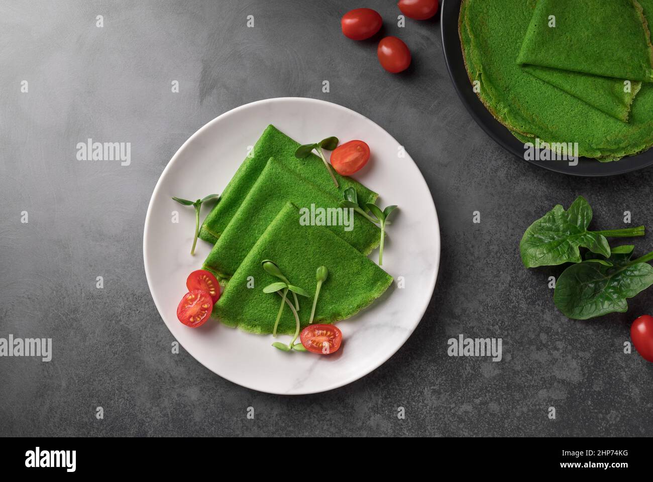 vegan green spinach crepes served with fresh vegetables Stock Photo - Alamy