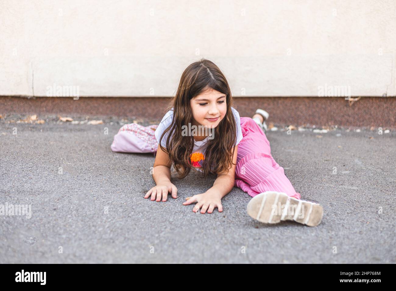 Little brunette girl casually doing split outdoors Stock Photo - Alamy