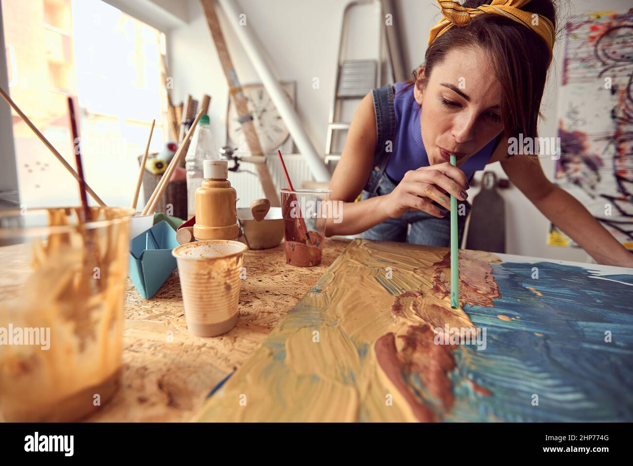 A young female artist is using different techniques while working on a ...