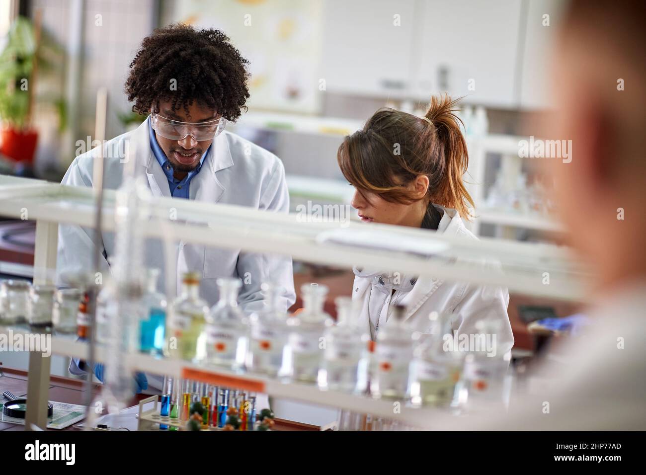 Young students carefully working with chemicals in a sterile ...