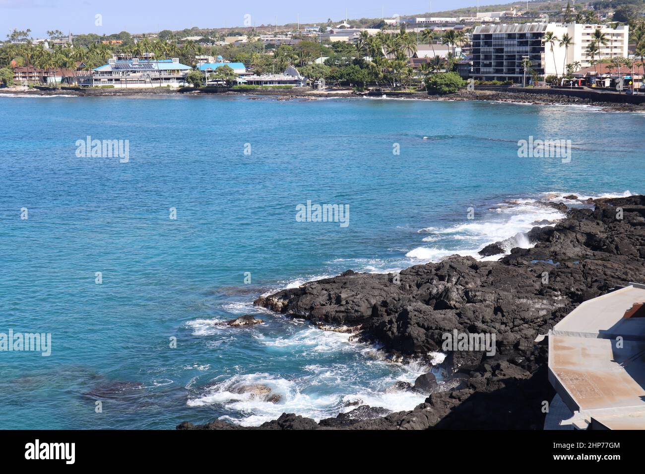 Scenic view of Oneo Bay and black volcanic rock on the shoreline in ...
