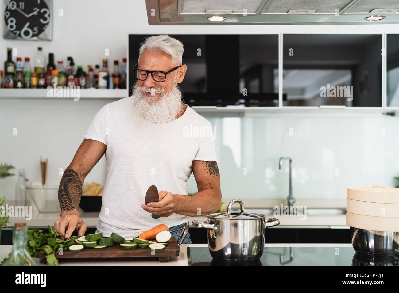 Happy senior man having fun cooking at home - Elderly person preparing ...
