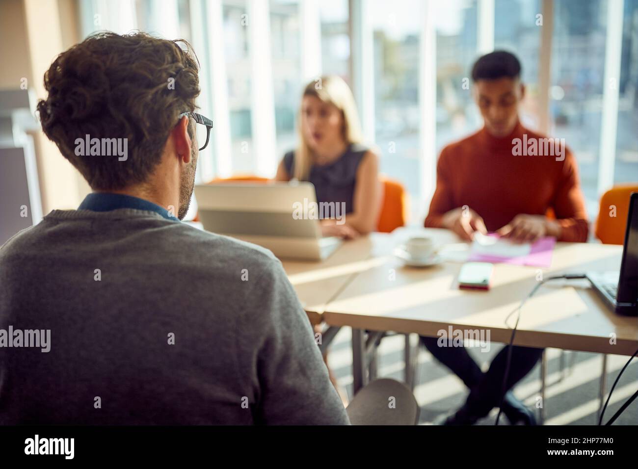 A young man is having an interview for a job position in front of a ...