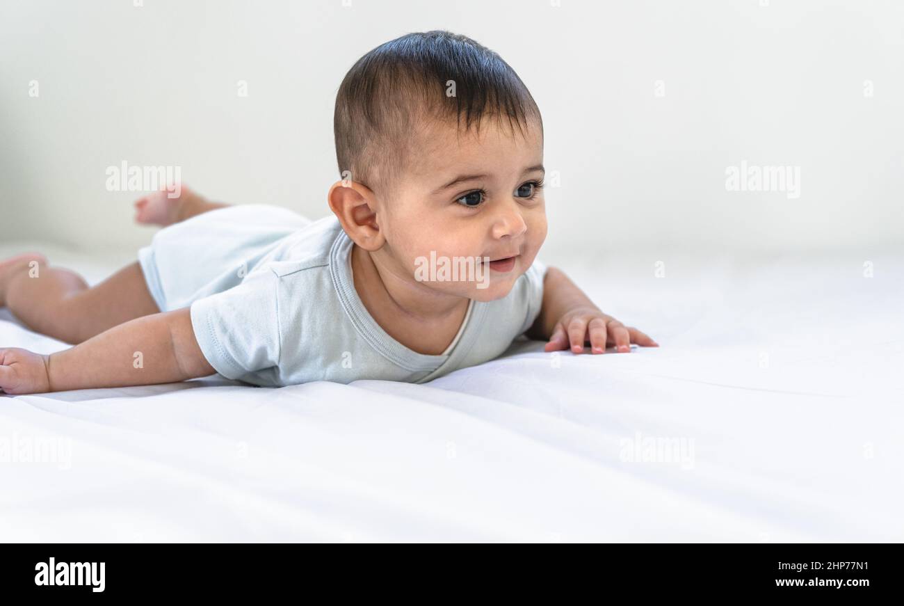 Portrait of happy little baby lying on bed Stock Photo - Alamy