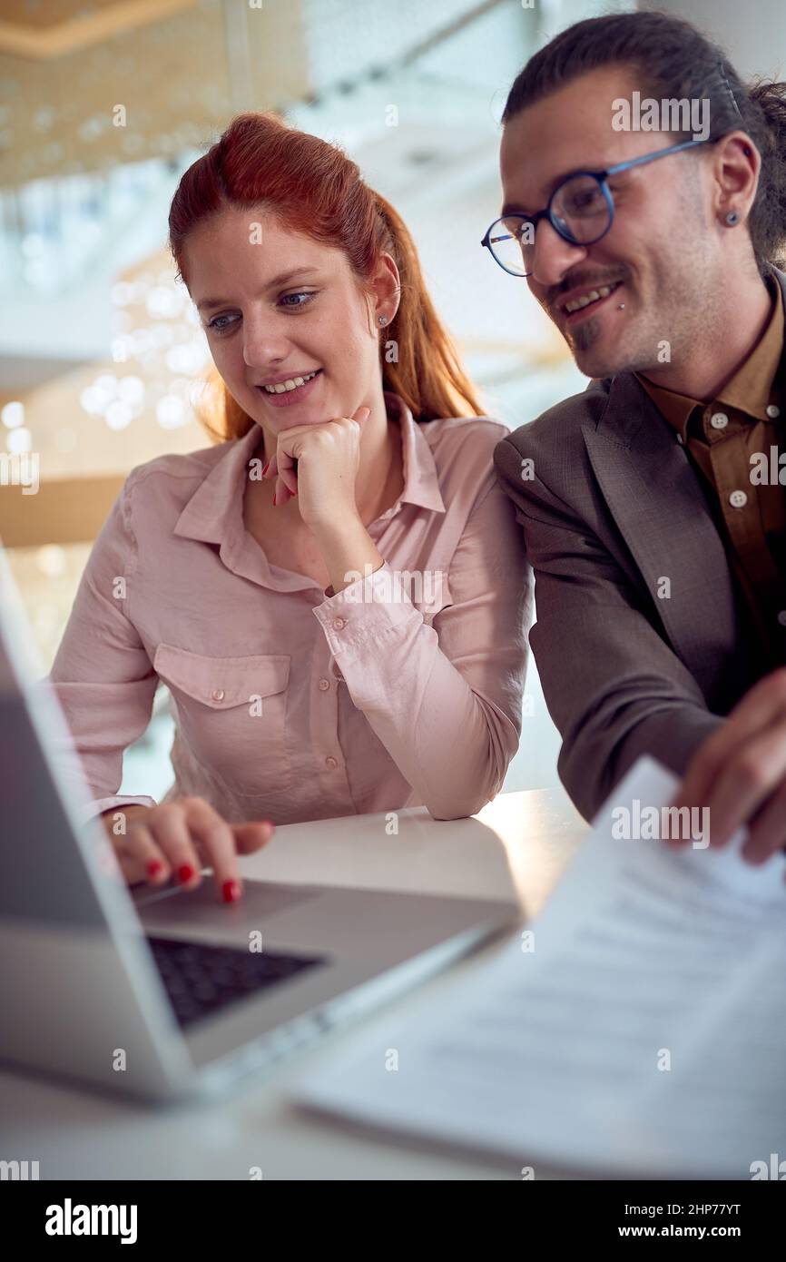 Two young business colleagues in a friendly atmosphere at the office ...