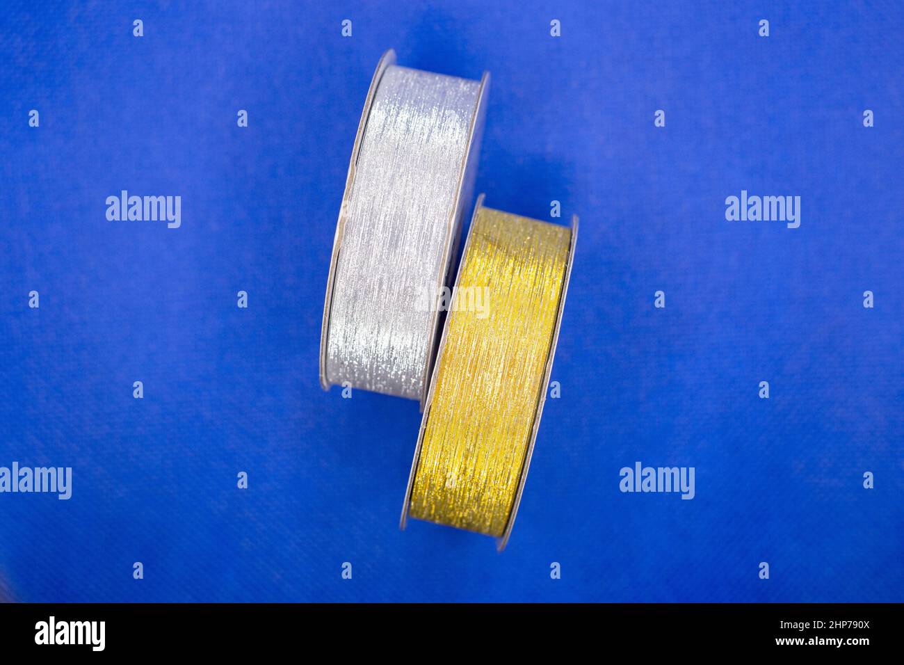 Two packing tapes in gold and silver blue background Stock Photo - Alamy