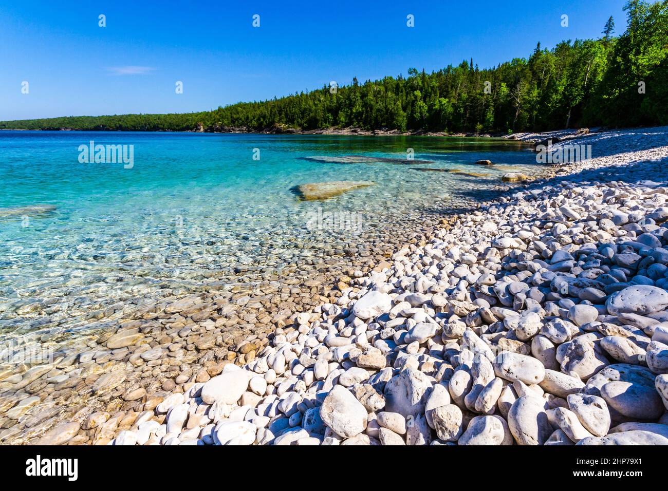 White, stony coastline lake Huron. Crystal clear water shows limestone ...