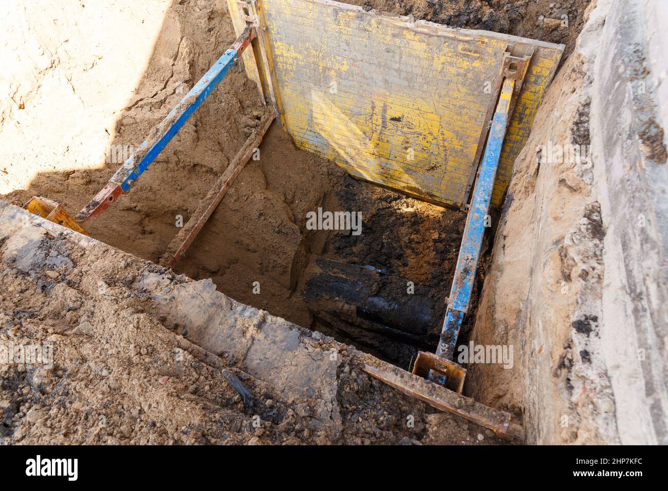 Trench to repair the pipe break. Walls reinforced with metal supports ...