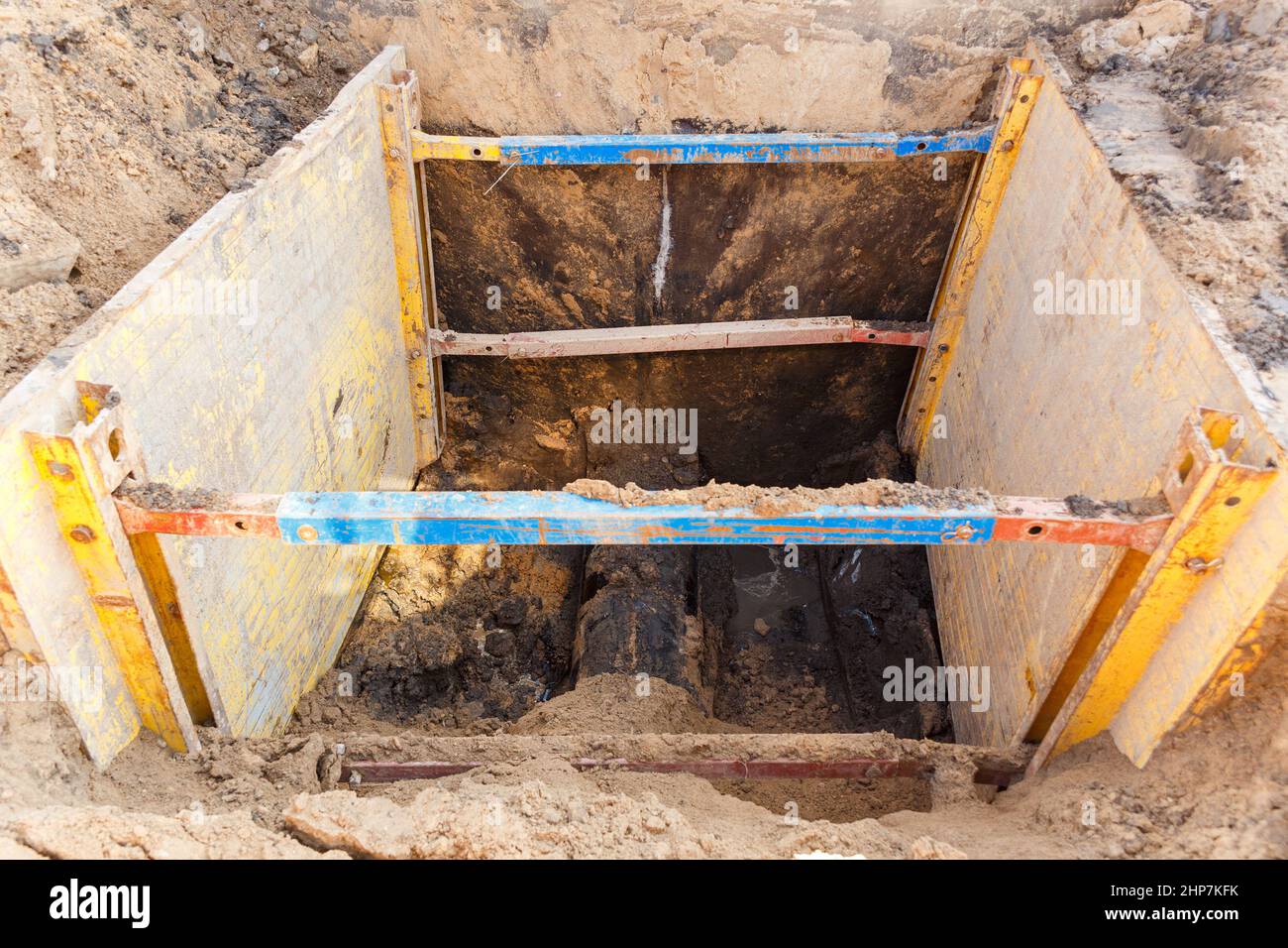 Trench to repair the pipe break. Walls reinforced with metal supports ...