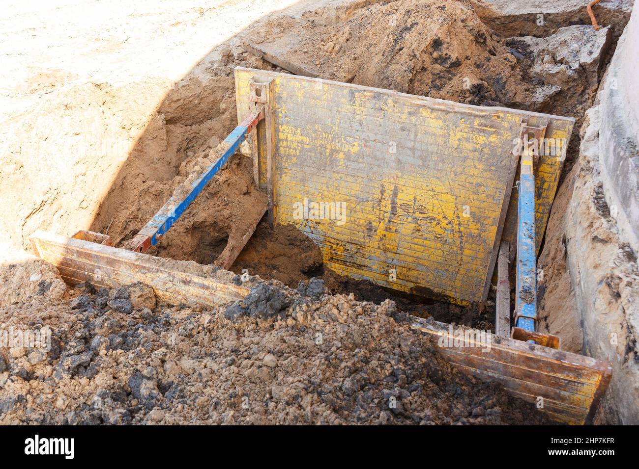 Trench to repair the pipe break. Walls reinforced with metal supports ...