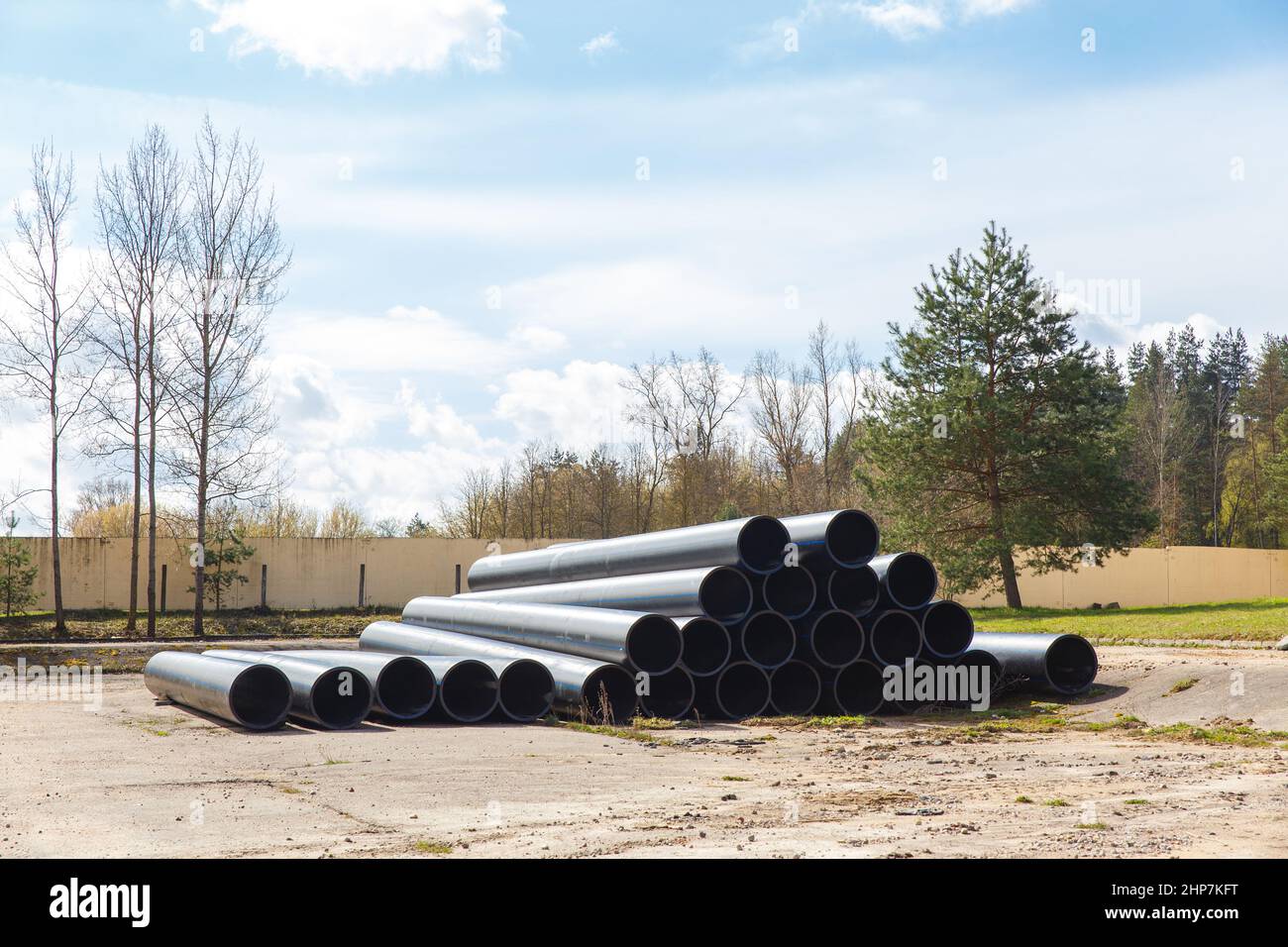 HDPE pipe for water supply stacked on the platform under the open sky ...