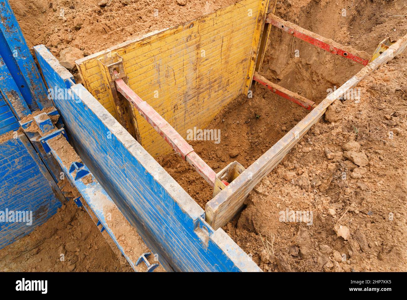 Installation of metal supports to protect the walls of the trench. The ...
