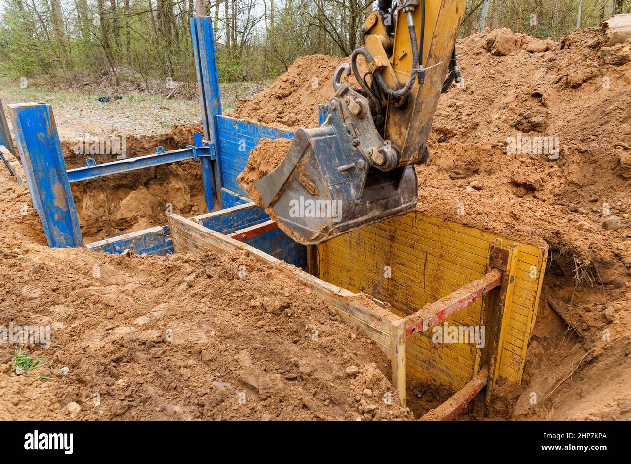 Installation of metal supports to protect the walls of the trench. The ...