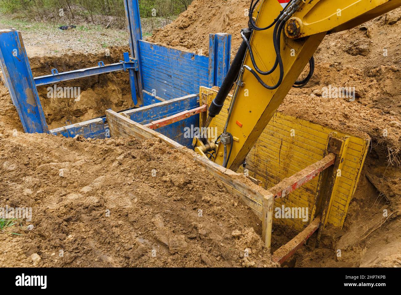 Installation of metal supports to protect the walls of the trench. The ...