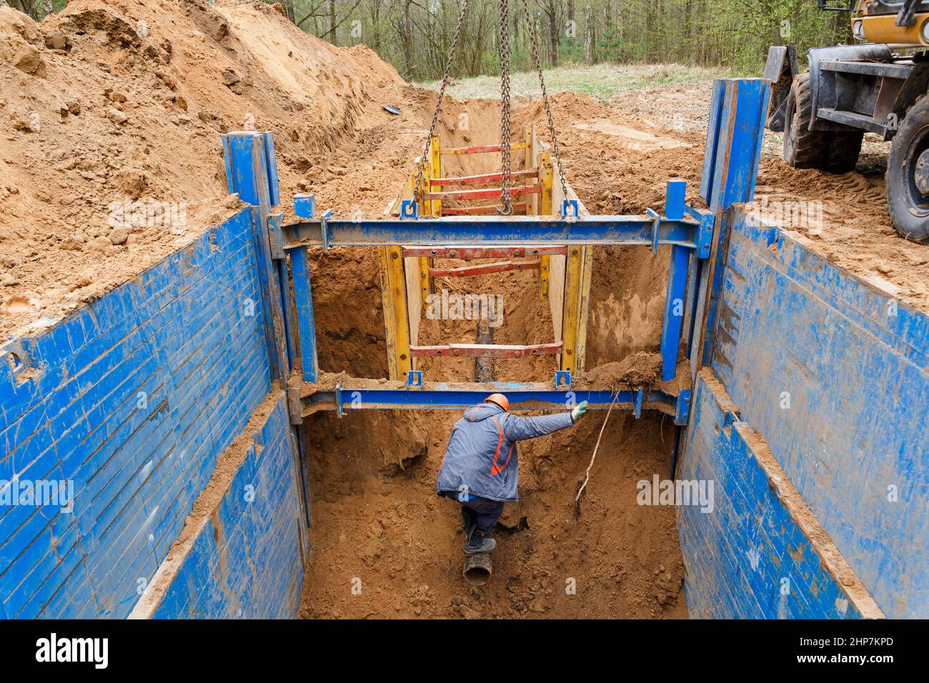 Installation of metal supports to protect the walls of the trench. The ...