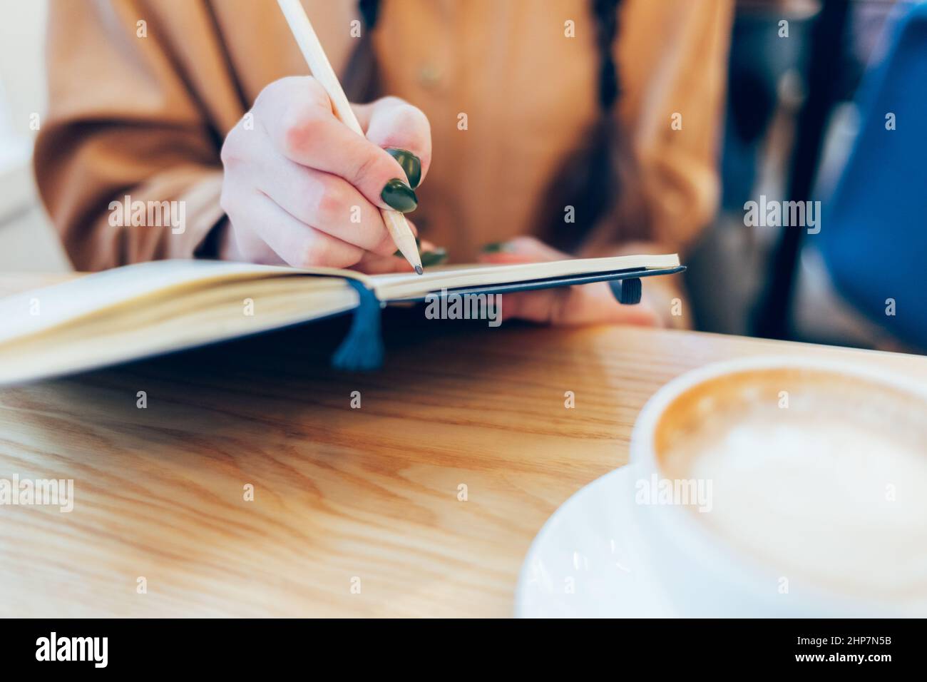 Young woman studying, close-up of hands writing in paper notebook Stock ...