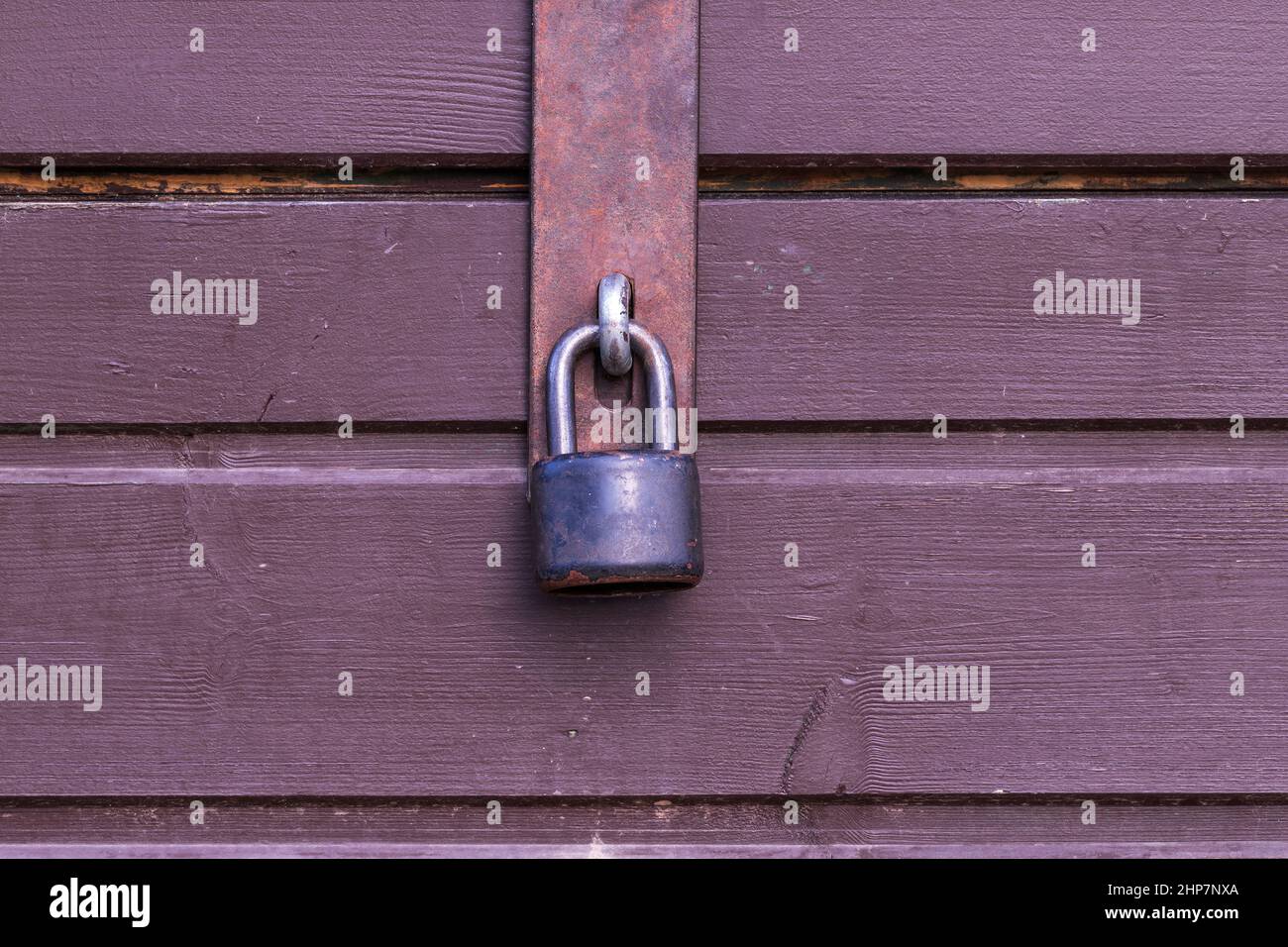 Black padlock on the door of a wooden stand. Locked window with a ...